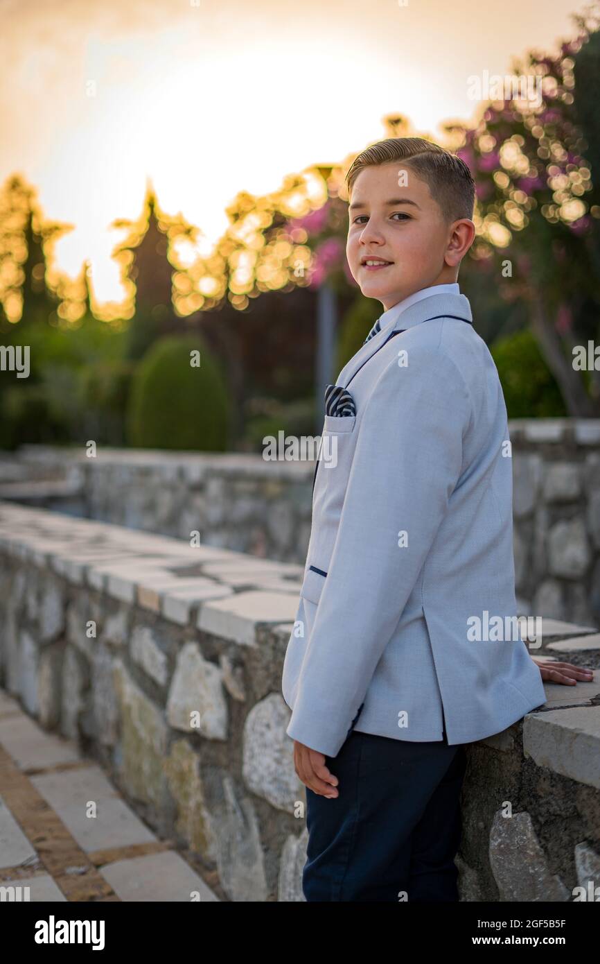 Vertical shot of an adorable male child in a formal suit outfit posing ...