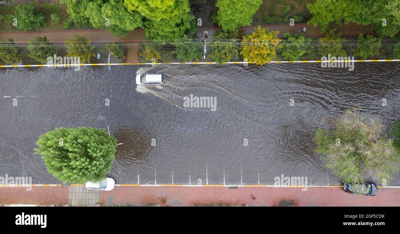 Flooded street after an abnormal downpour in the suburbs. Cars move on ...