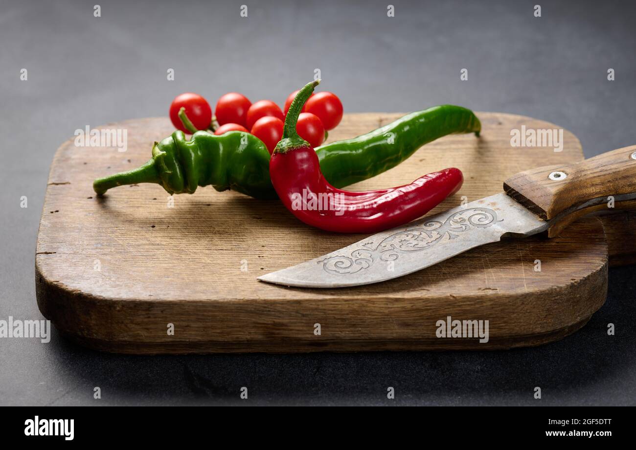fresh pods of hot pepper on a wooden cutting board. Hot spice Stock ...