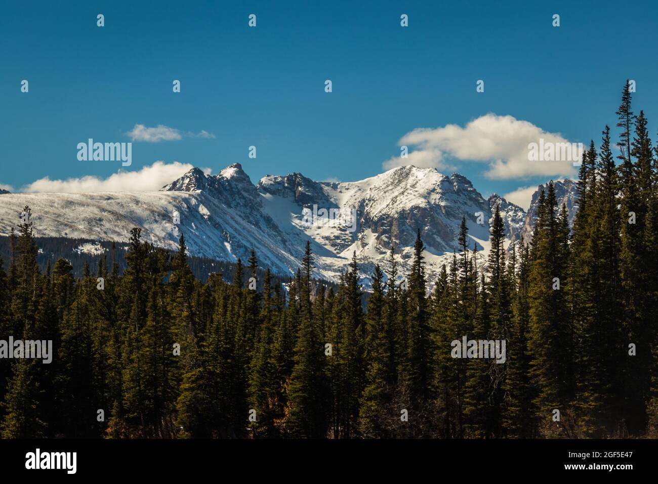 A wide angle landscape shot of dramatic, snowy mountain peaks covered ...
