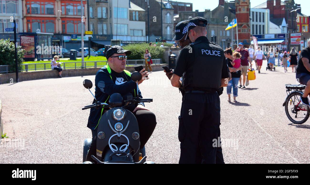 Police officers speak to the rider of a disability scooter at Morecambe ...