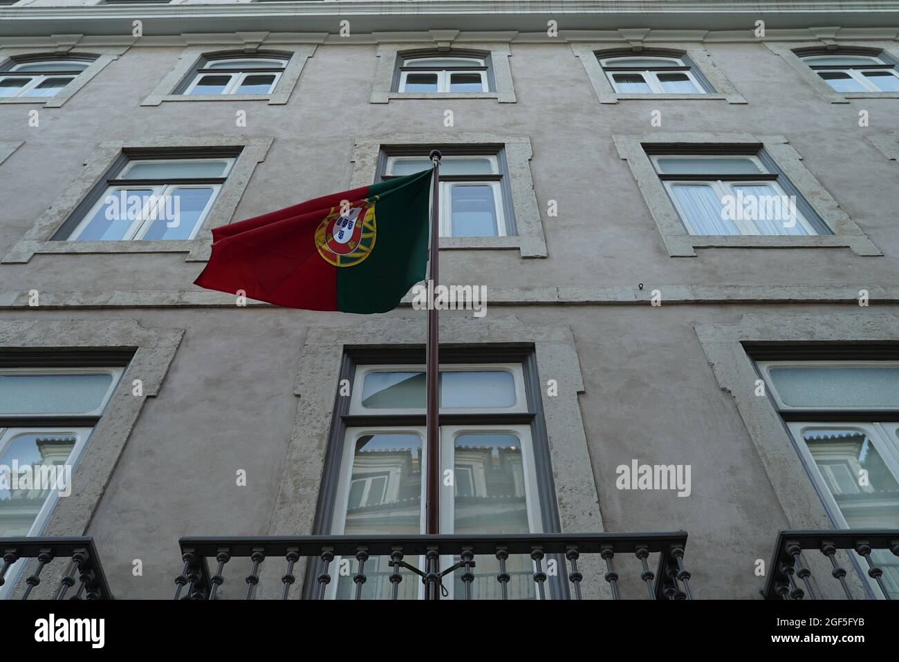 Low angle shot of white building with windows and a portugal flag Stock ...