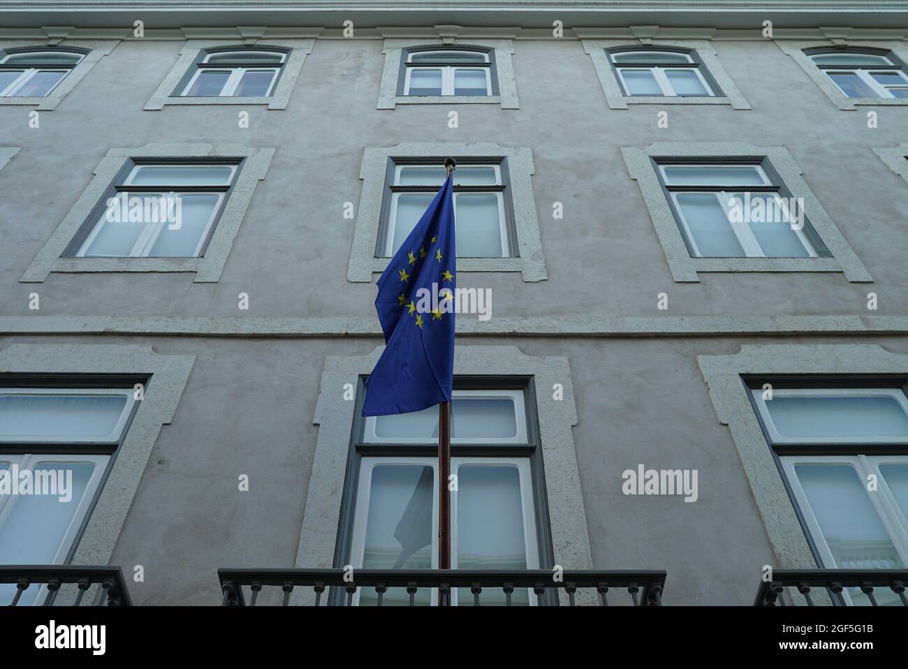 Low angle shot of white building with windows and a European union blue ...