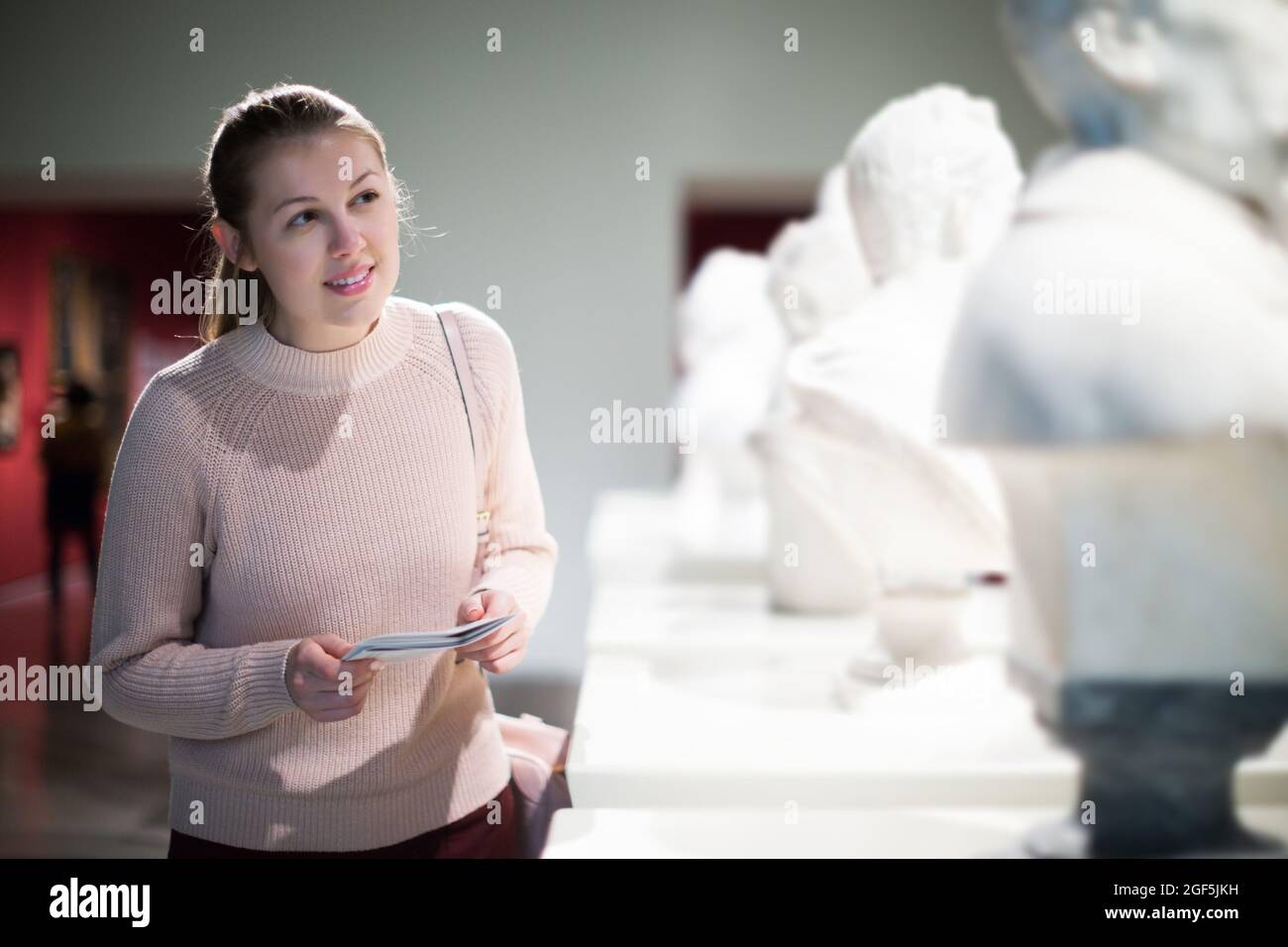 woman with guidebook standing in museum Stock Photo - Alamy