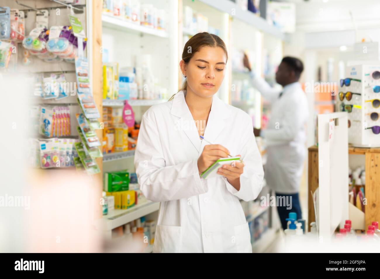 Portrait of a focused young female pharmacist making important work ...