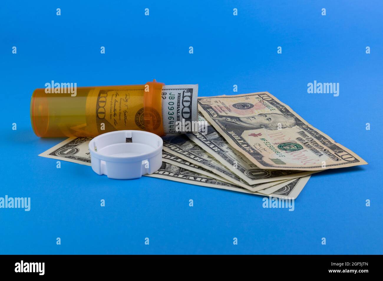 Hundred dollar bill and smaller dollar bills with a pill bottle ...