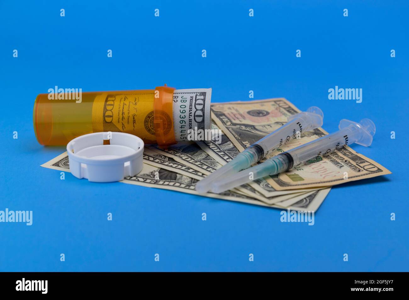 Hundred dollar bill and smaller dollar bills with a pill bottle and ...
