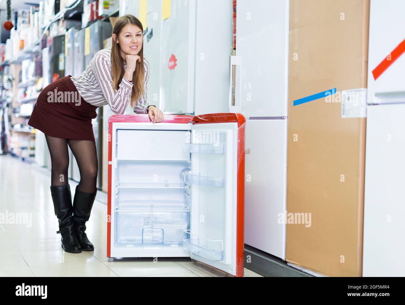 female seller showing refrigerator Stock Photo - Alamy