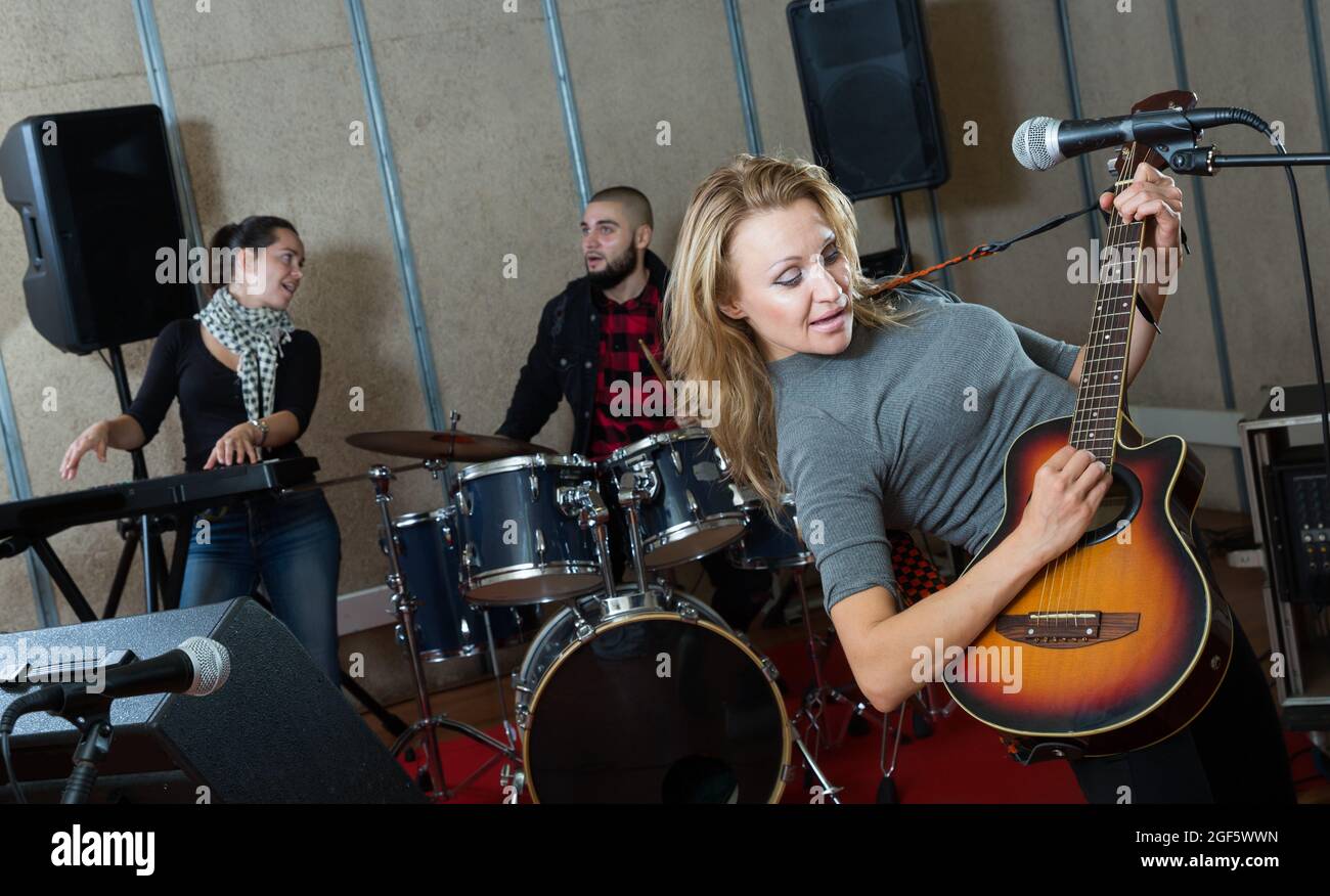 Lovely guitar player and singer with band Stock Photo - Alamy