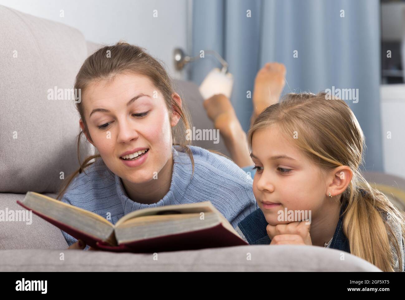 Mother and daughter reading book Stock Photo - Alamy