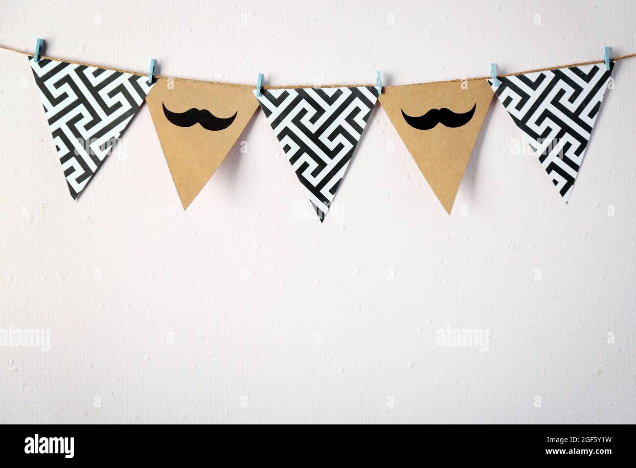 Triangle garland with mustache and pattern on wall Stock Photo - Alamy