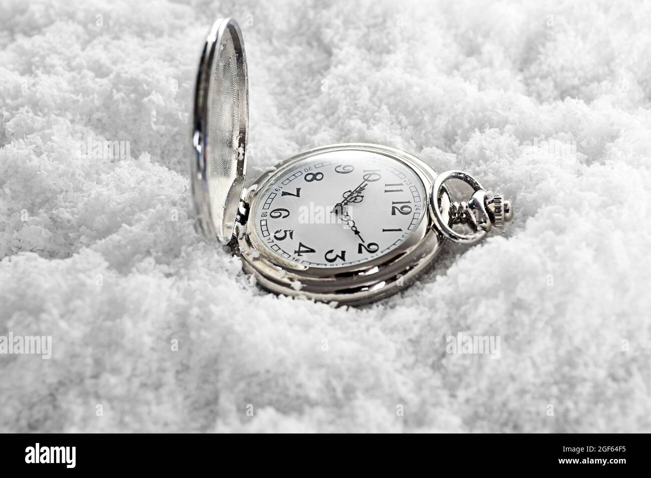 Pocket watch over white snow background Stock Photo - Alamy