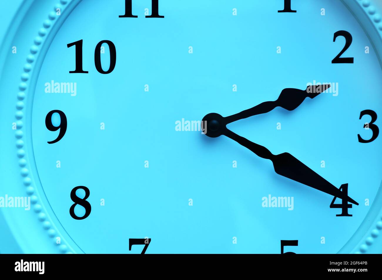 Clock face in blue light closeup Stock Photo - Alamy
