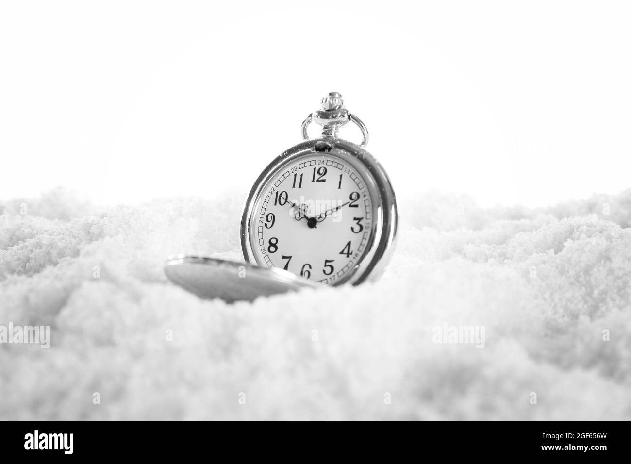 Pocket watch over white snow background Stock Photo - Alamy