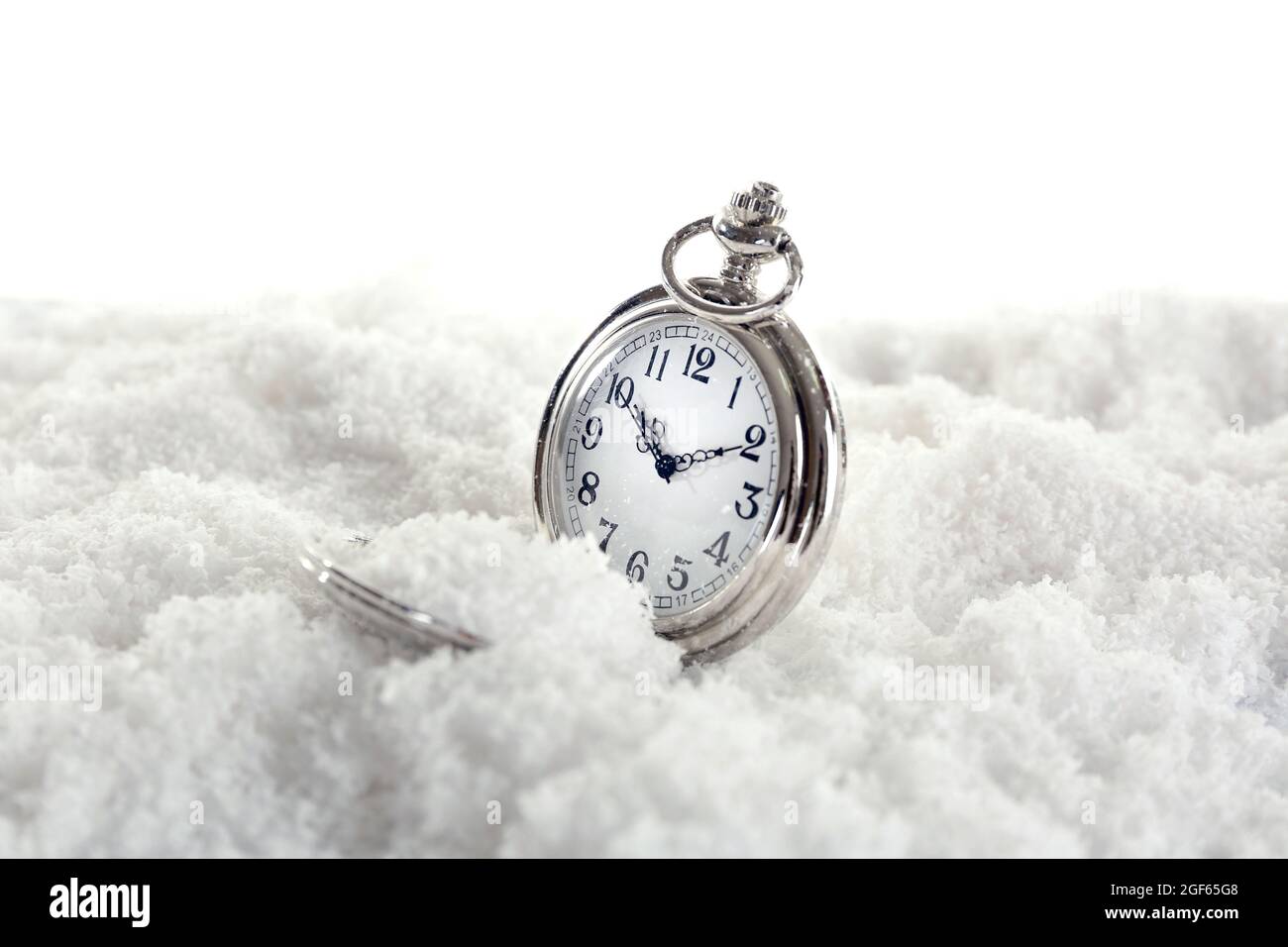 Pocket watch over white snow background Stock Photo - Alamy
