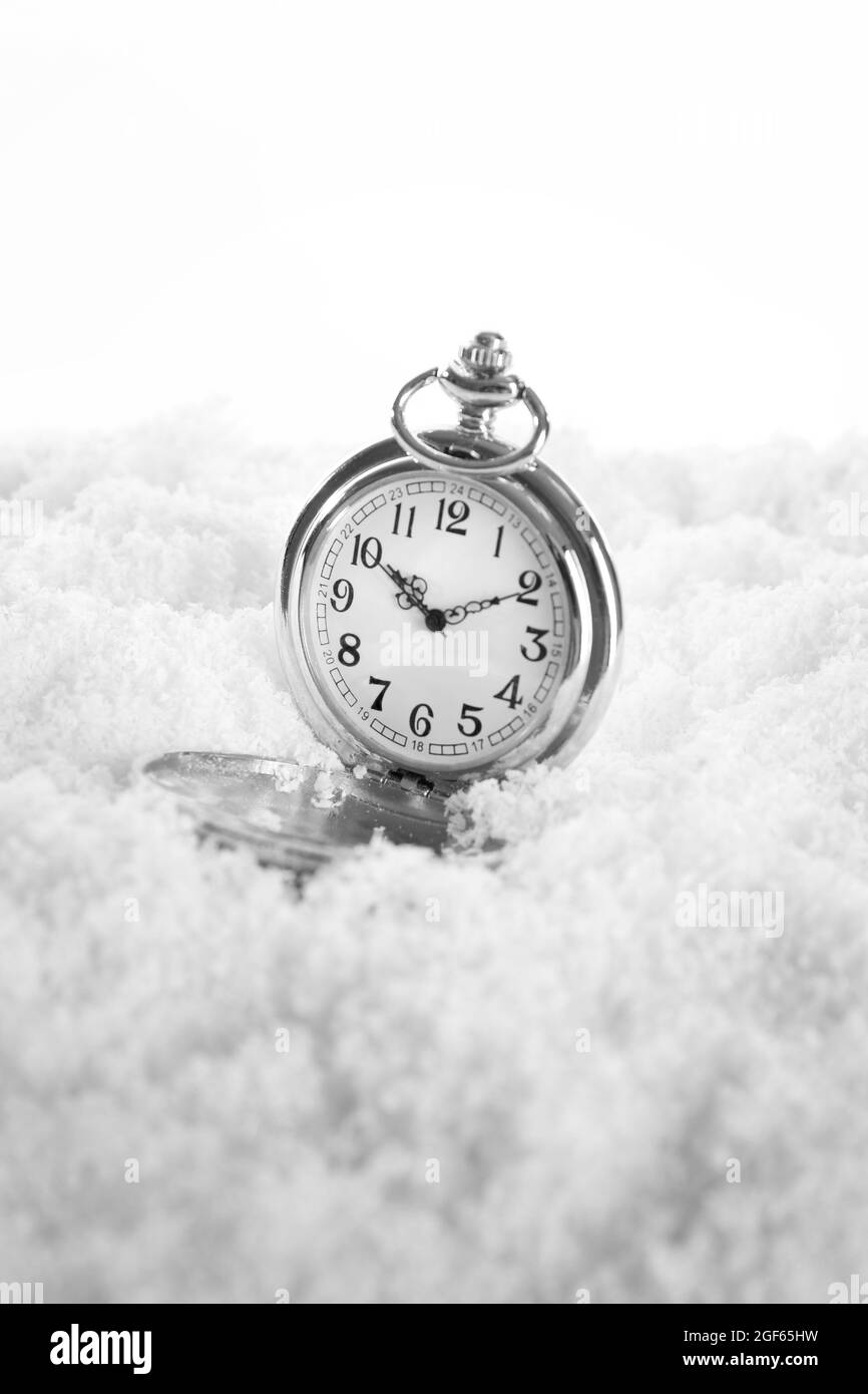 Pocket watch over white snow background Stock Photo - Alamy