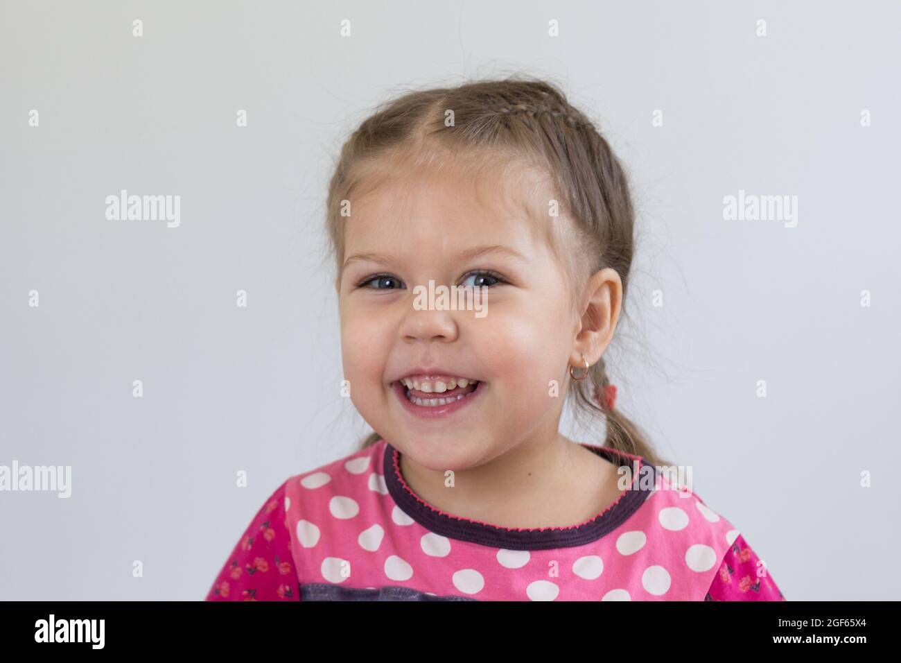 Portrait of smiling caucasian child of three years old looking at ...