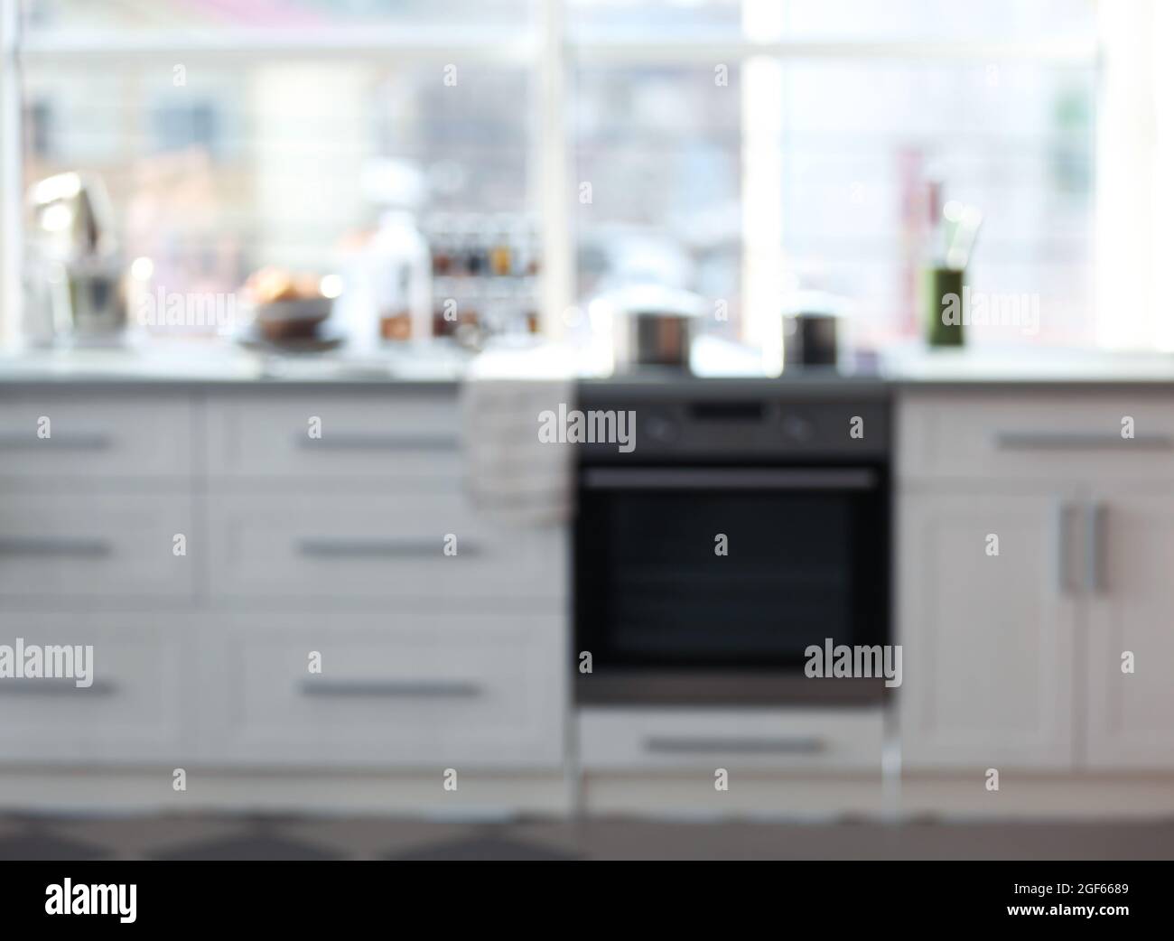 Blurred modern kitchen interior with light furniture and electric stove ...