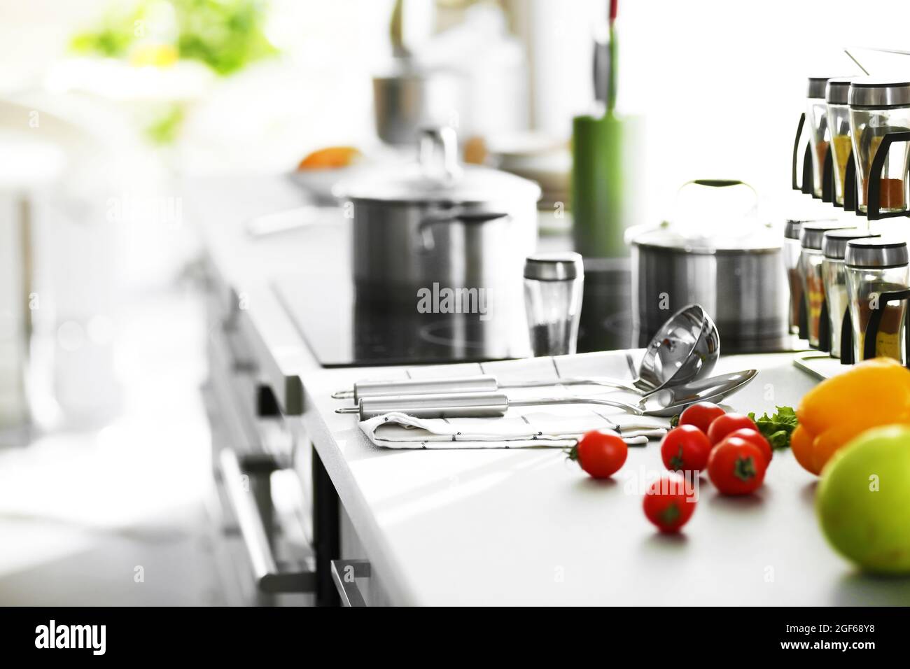 Modern table and electric stove with utensils and vegetables in the ...