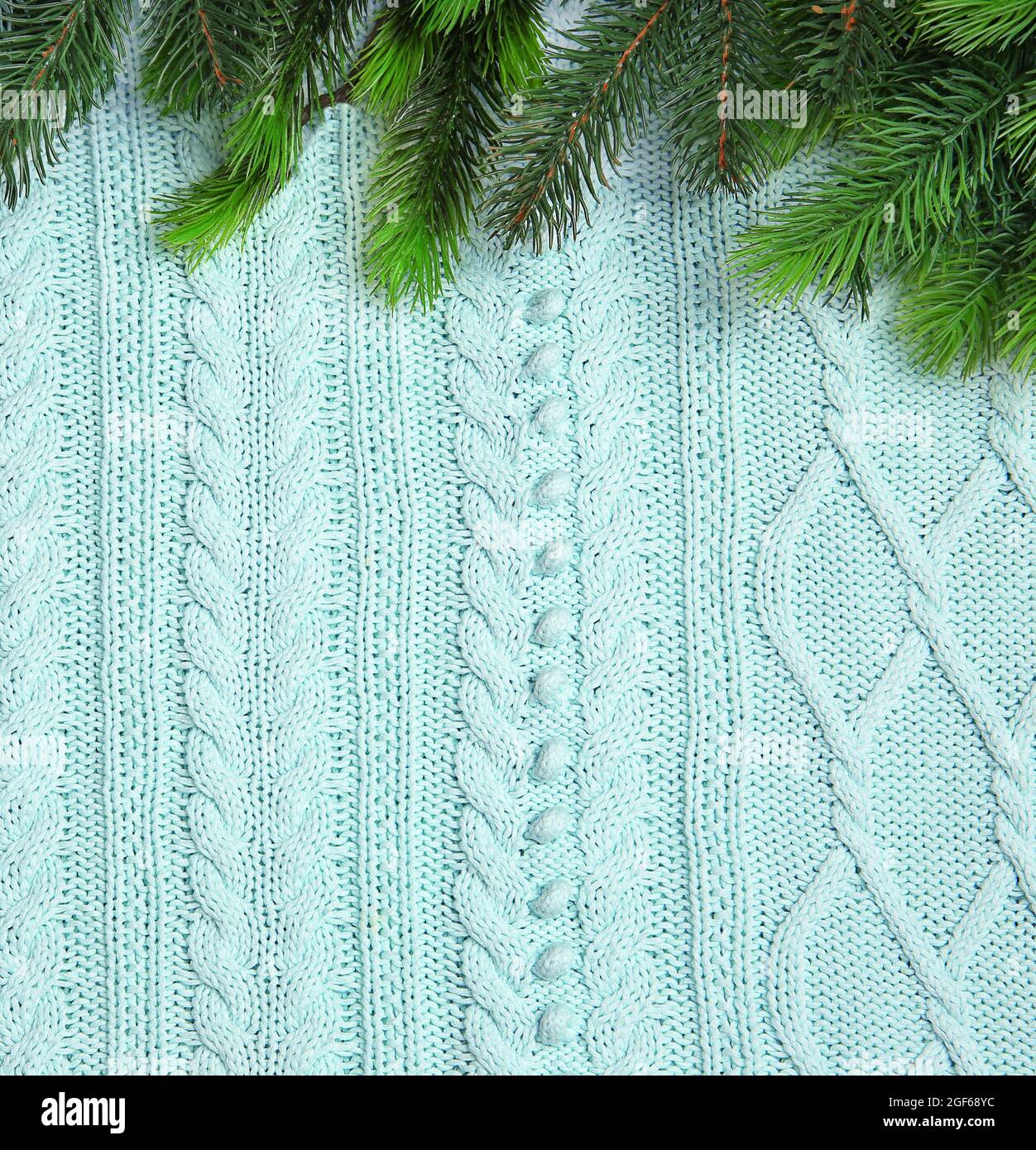 Fir twigs on knitted pattern background Stock Photo - Alamy