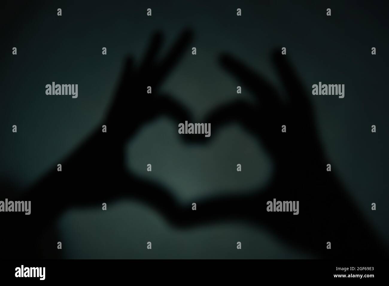 Hand shaped heart on dark background Stock Photo - Alamy