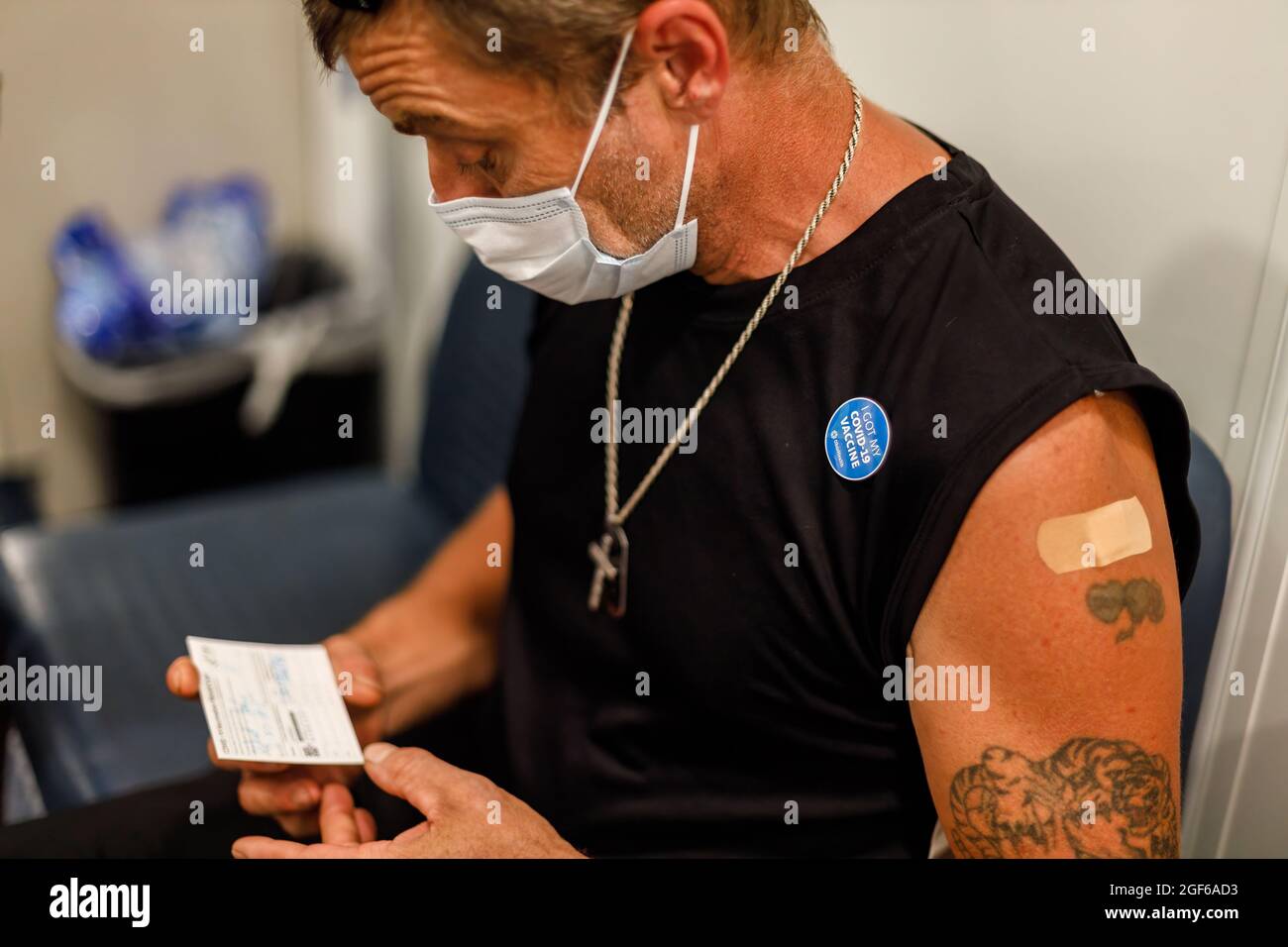 A man looks at his Coronavirus (COVID-19) vaccination card.OhioHealth's ...