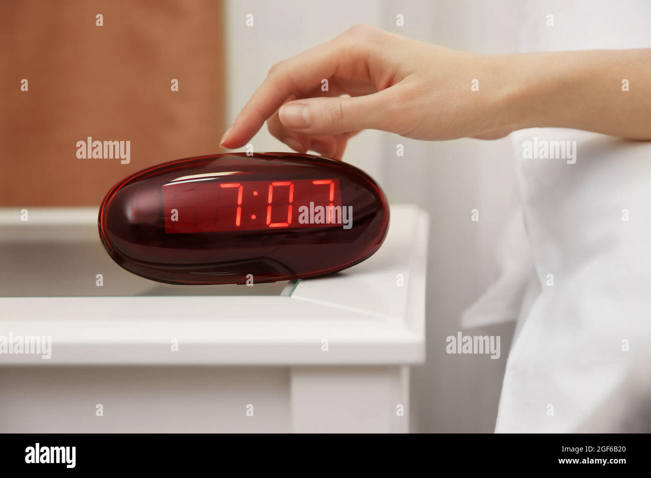 Female hand trying to stop digital clock ringing Stock Photo - Alamy