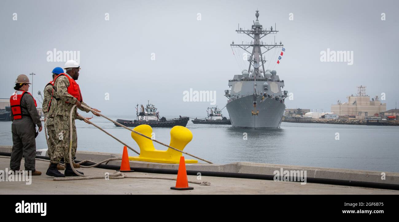Dock workers prepare tie-down ropes as USS Gridley (DDG 101) passes the ...
