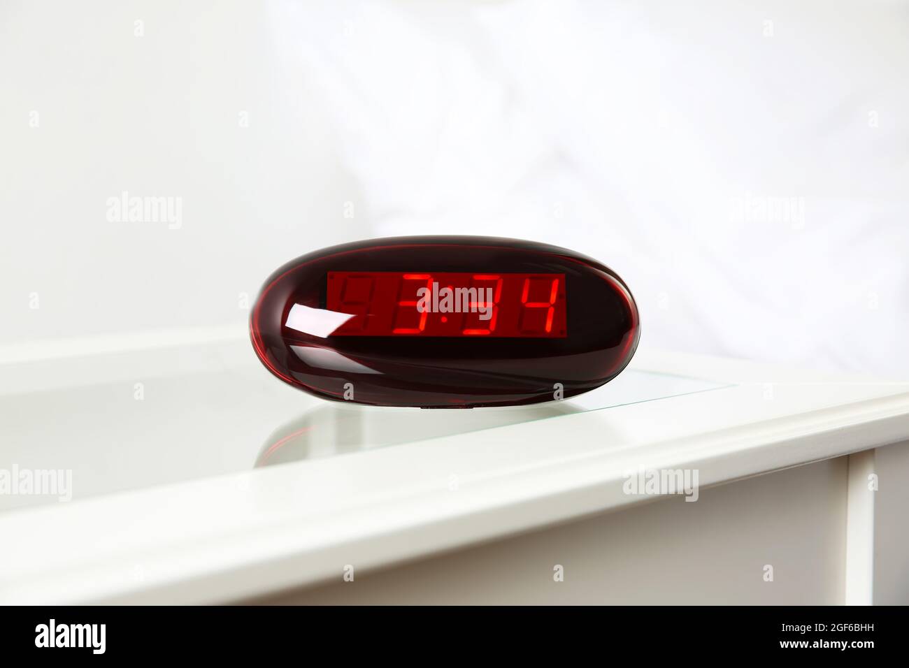 Digital clock on a bedside table in bedroom Stock Photo - Alamy