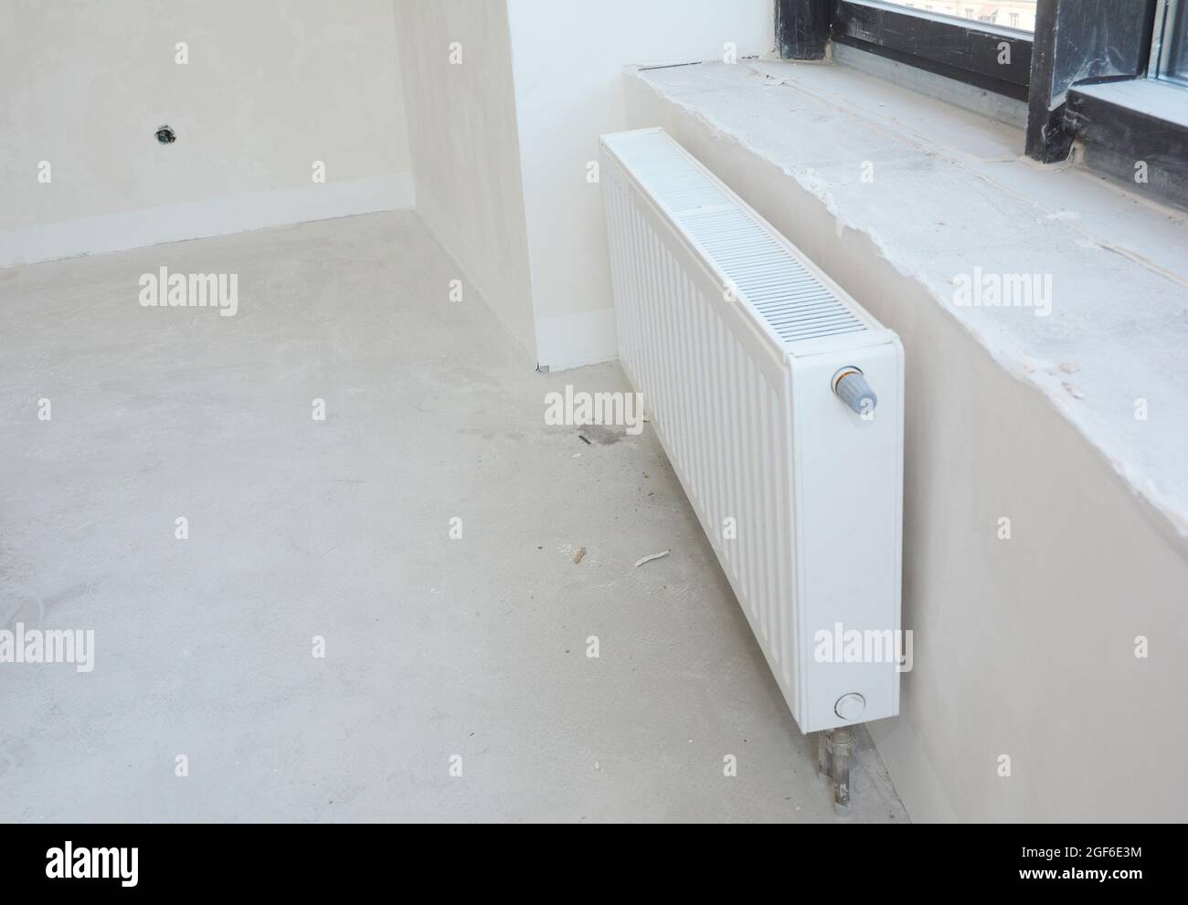 Installing radiator heater in empty house room Stock Photo - Alamy