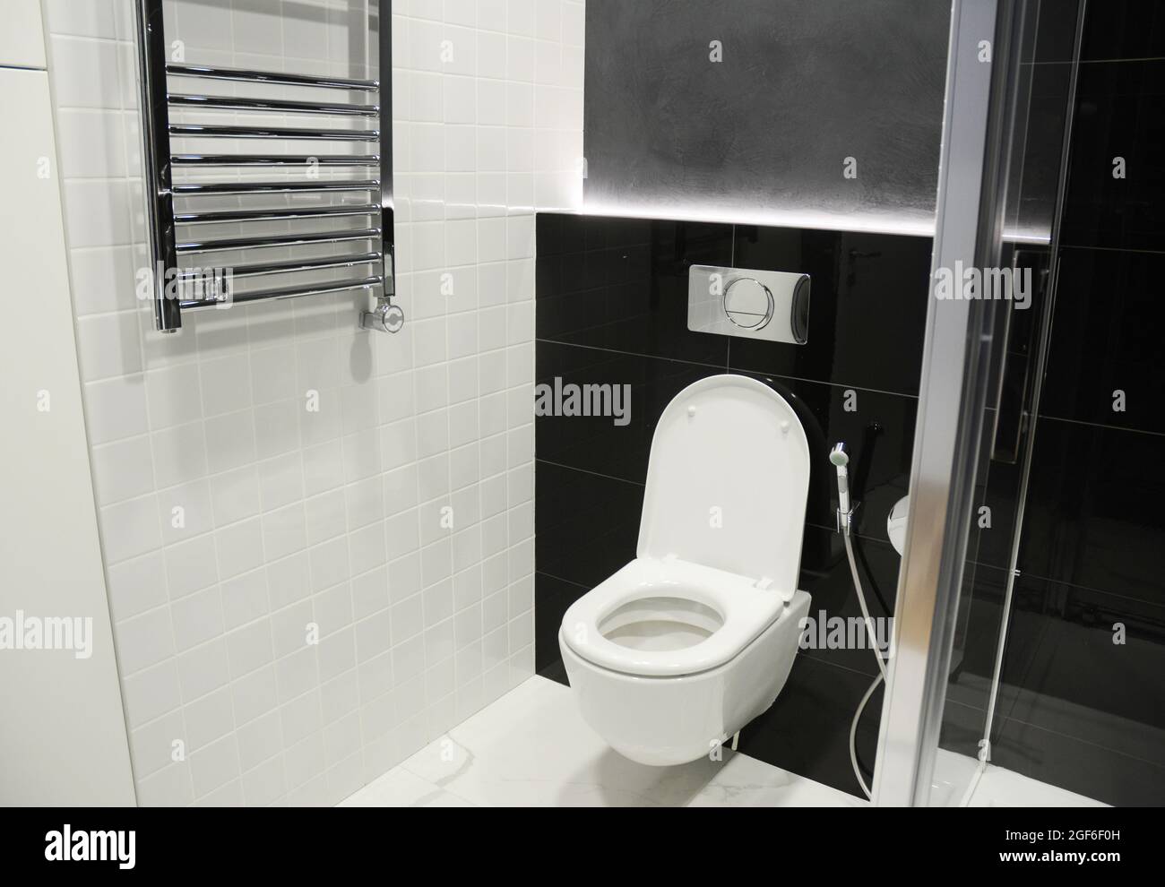 Contemporary bathroom with modern toilet bowl and electric towel rail ...