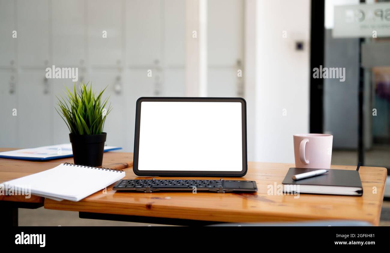 Shot of digital tablet with blank white screen, keyboard, cup of coffee ...