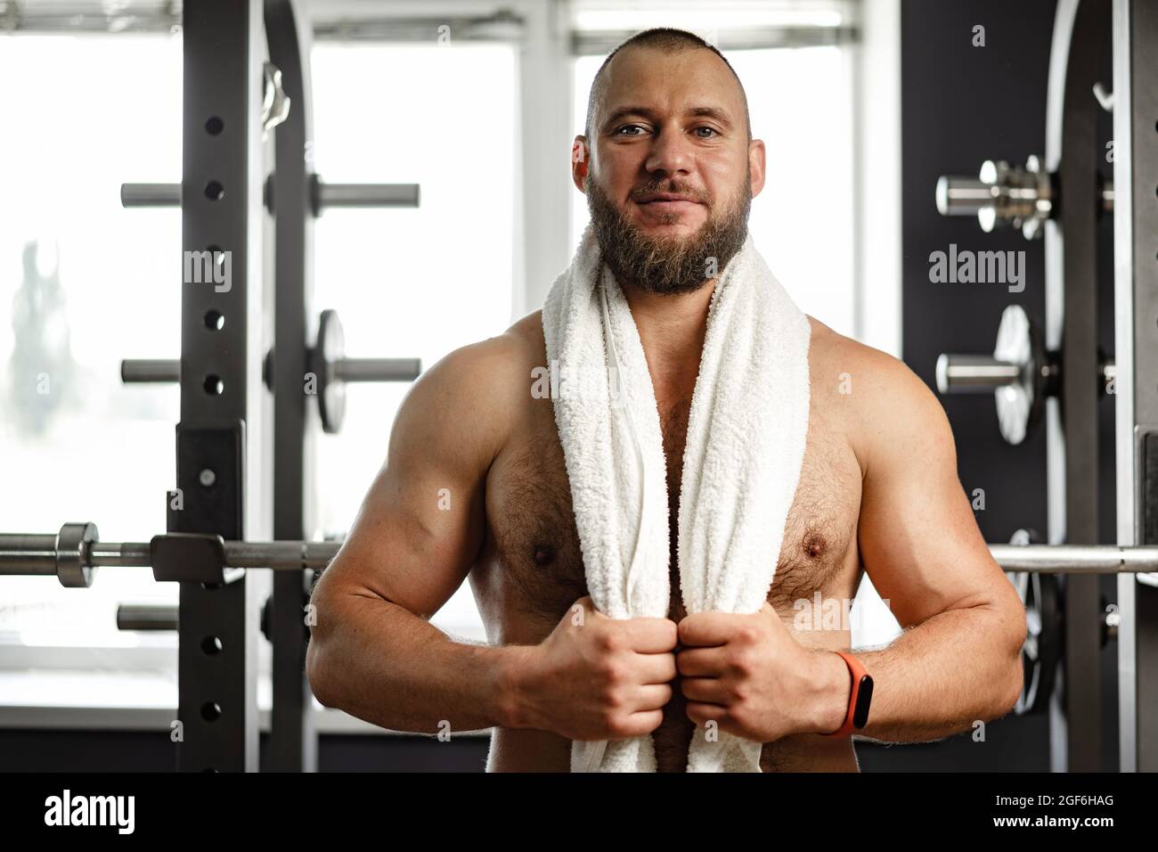 Cheerful smiling man bodybuilder standing in a gym Stock Photo - Alamy