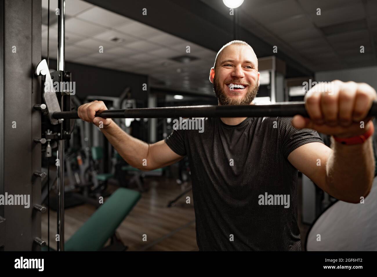 Cheerful smiling man bodybuilder standing in a gym Stock Photo - Alamy