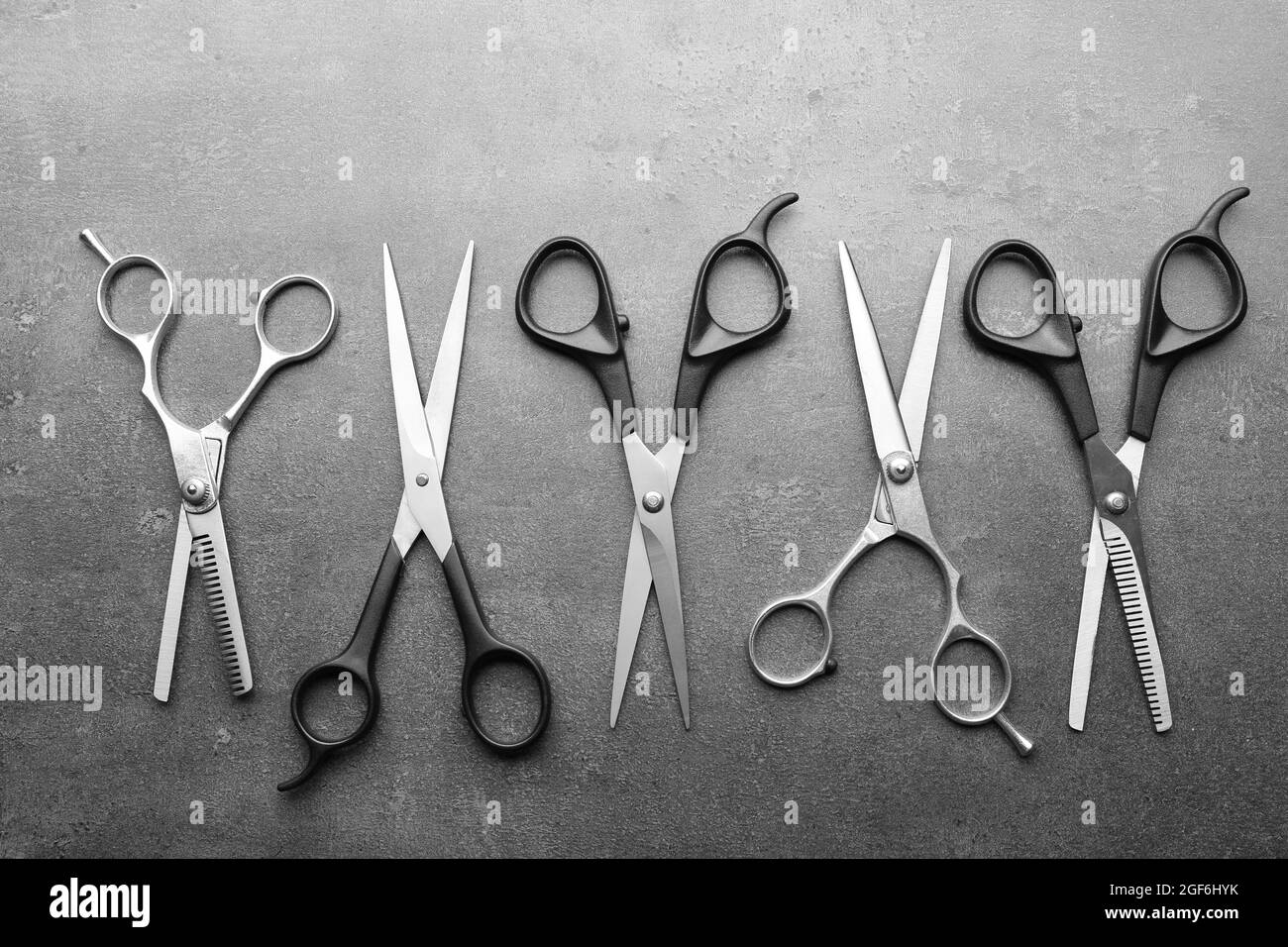 Professional metal scissors in different positions on a dark grey ...