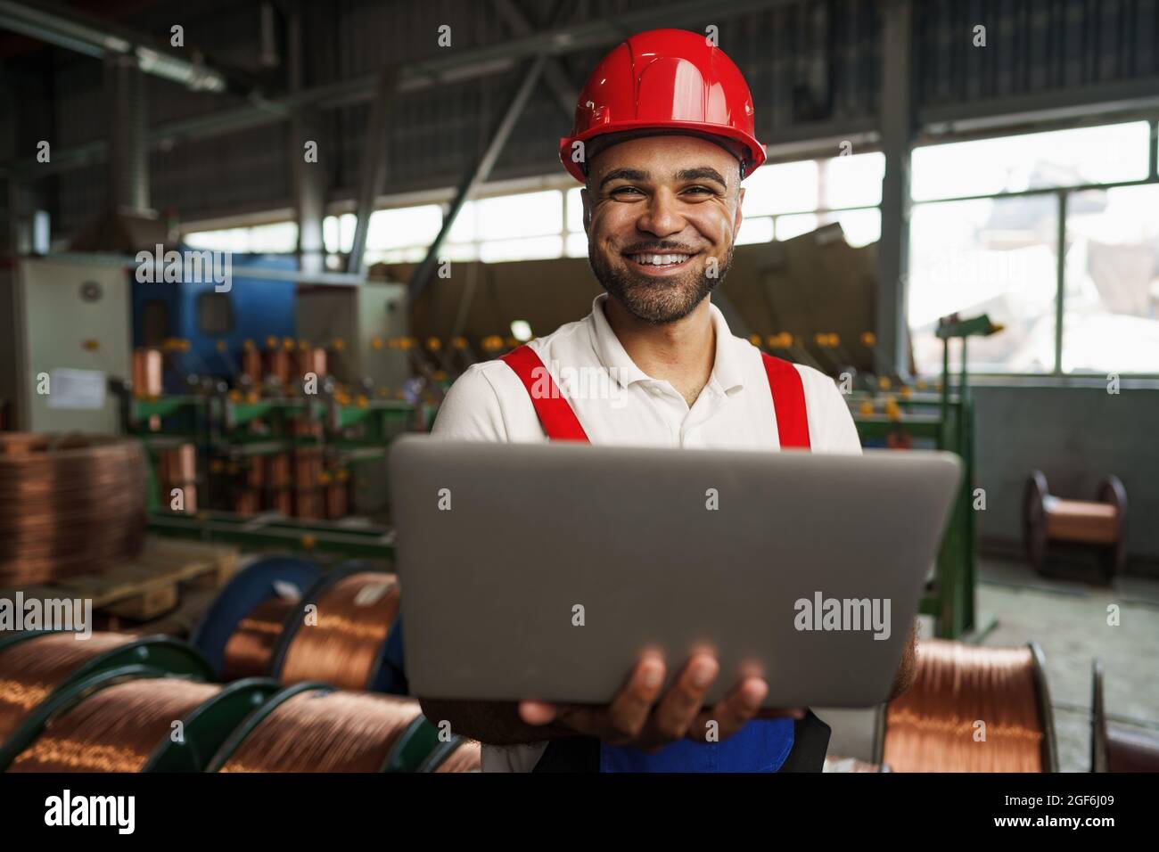 Industrial worker with laptop working in a cable production plant Stock ...