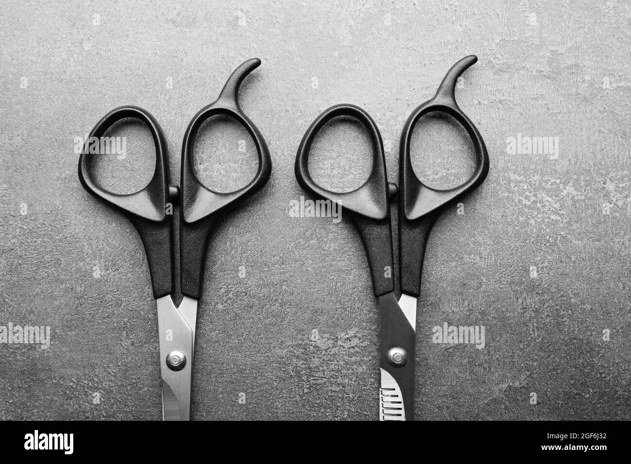 Professional scissors with black handles on a dark grey surface, top ...