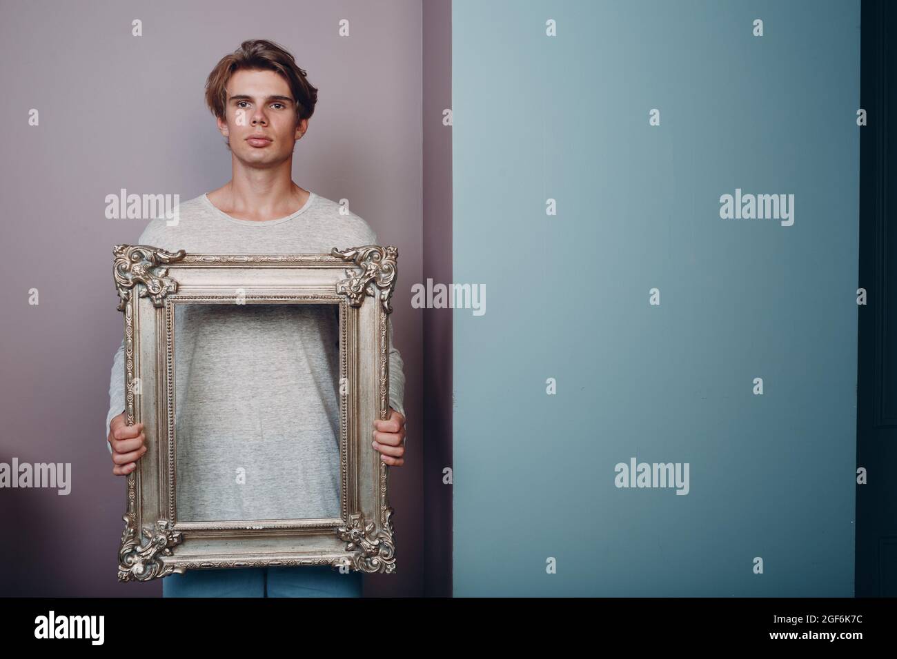 Millenial young man artist hold on gilded picture frame portrait Stock ...