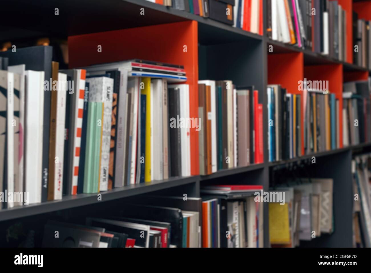 Blurred background with multi-colored books and catalogs on the shelves ...