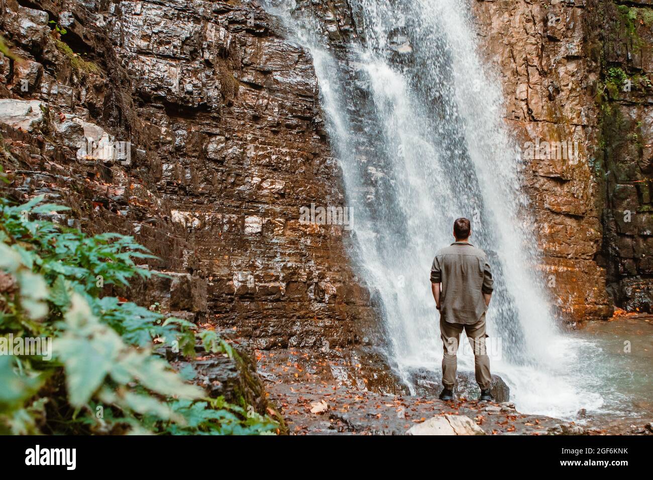 young strong man hiker looking the waterfall copy space Stock Photo - Alamy