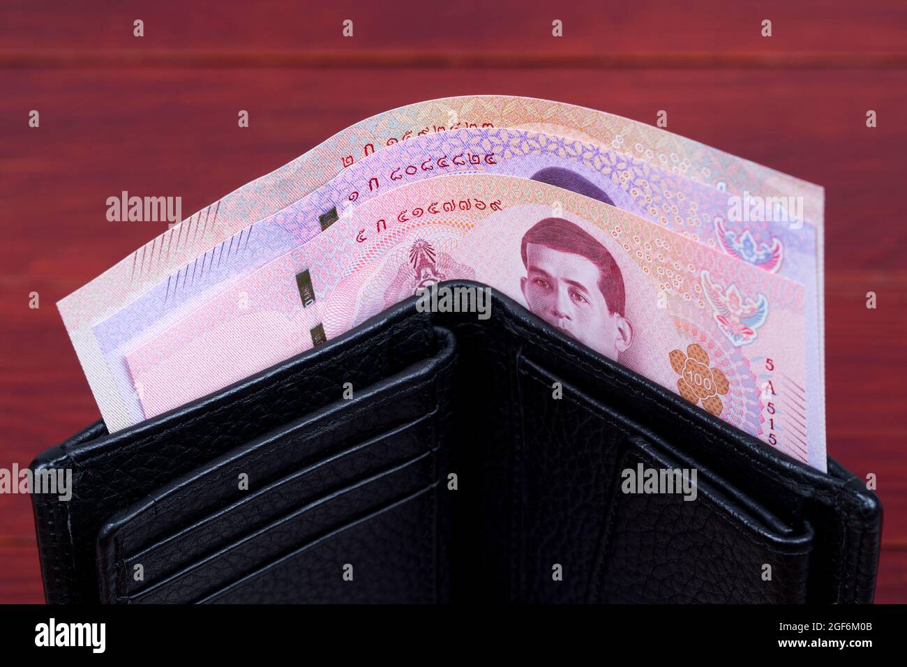 Thai money - baht in the black wallet Stock Photo - Alamy