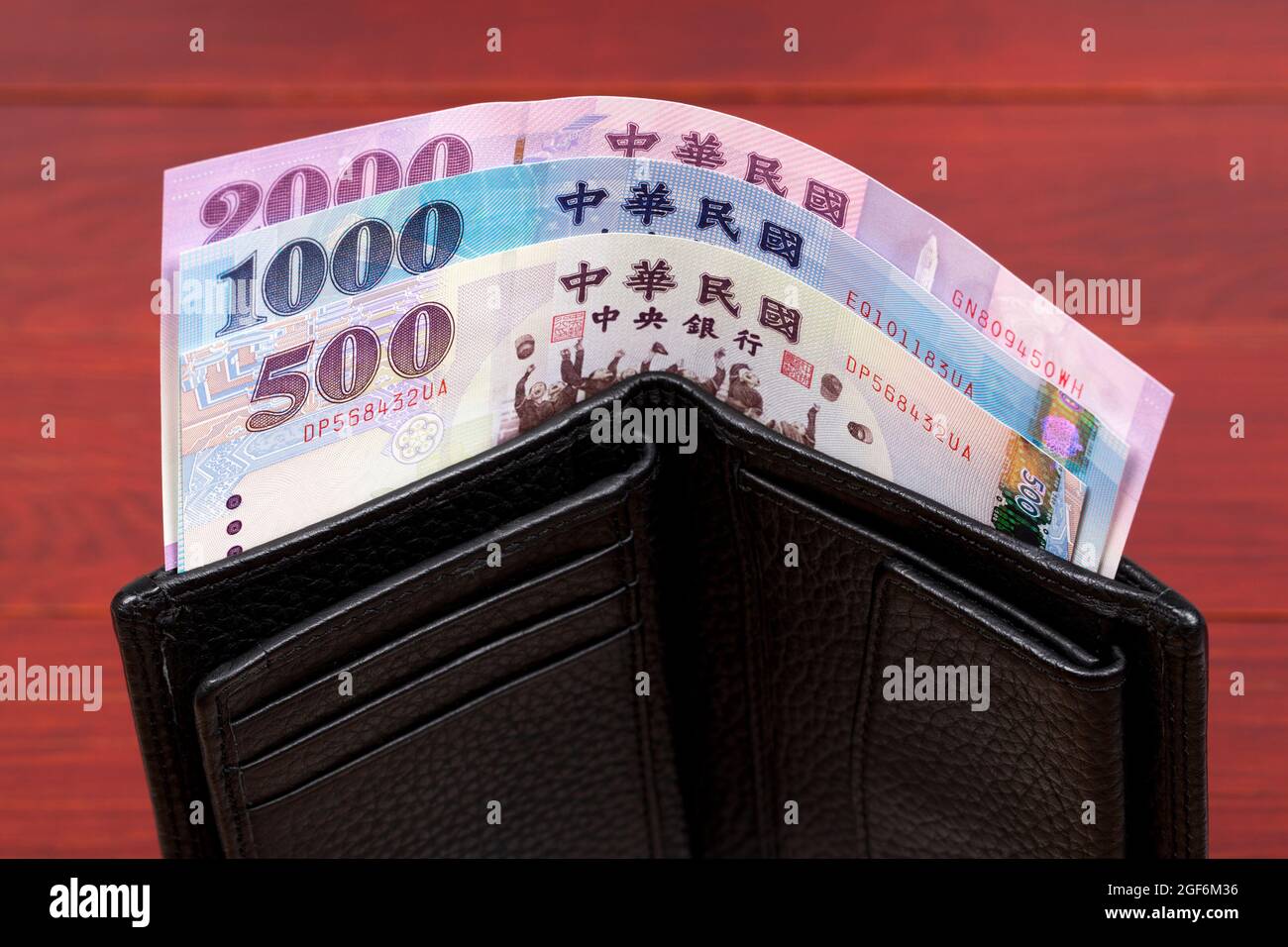 New Taiwan dollar in the black wallet Stock Photo - Alamy