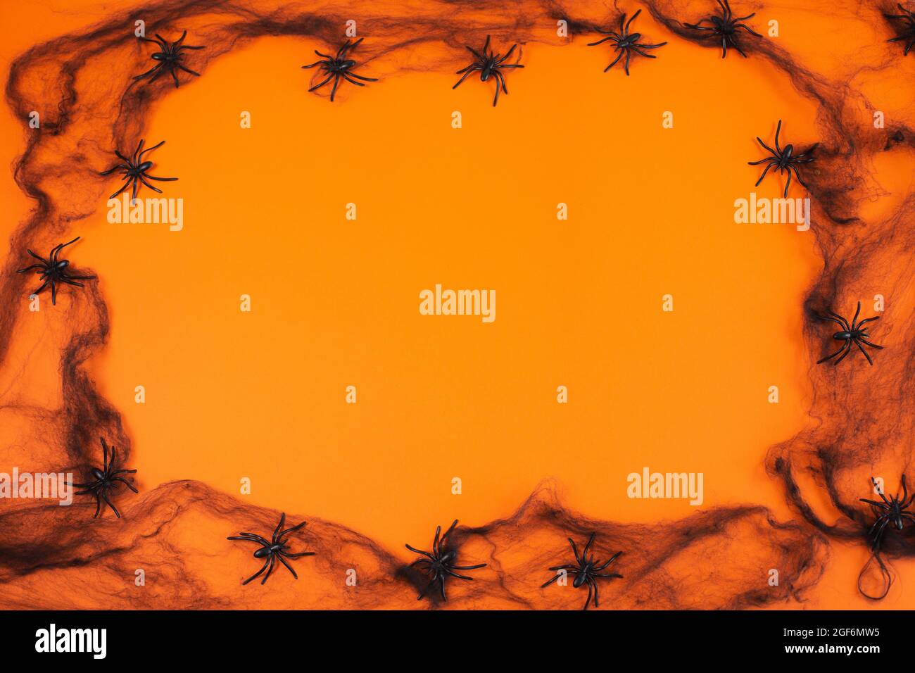 Modern Halloween background with black cobwebs and spiders on an orange ...