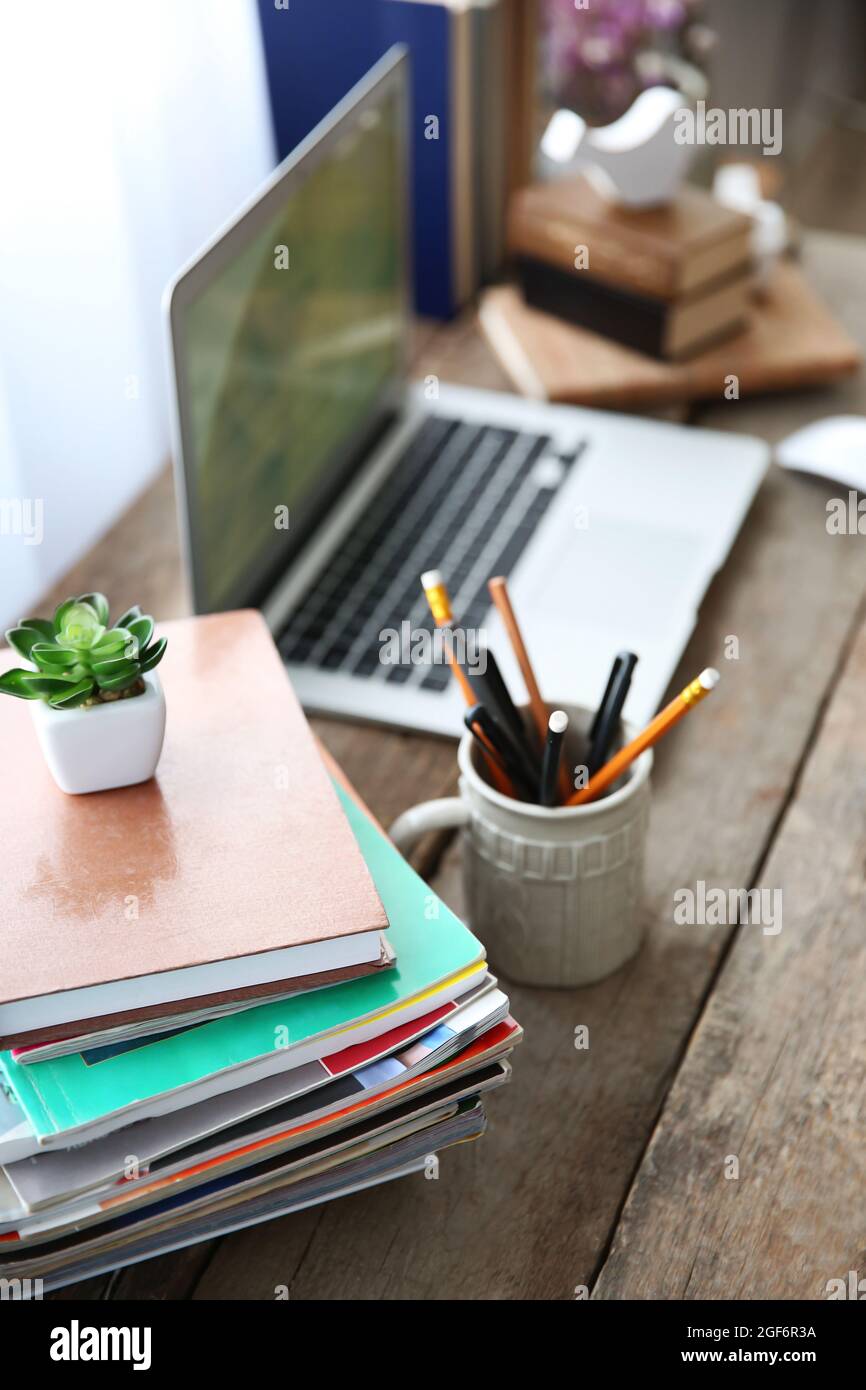 Workplace with laptop, table and books beside the window Stock Photo ...