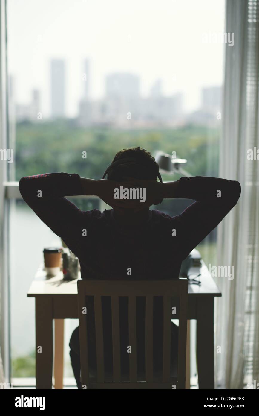 Silhouette of young man leaning back and stretching in his back after ...