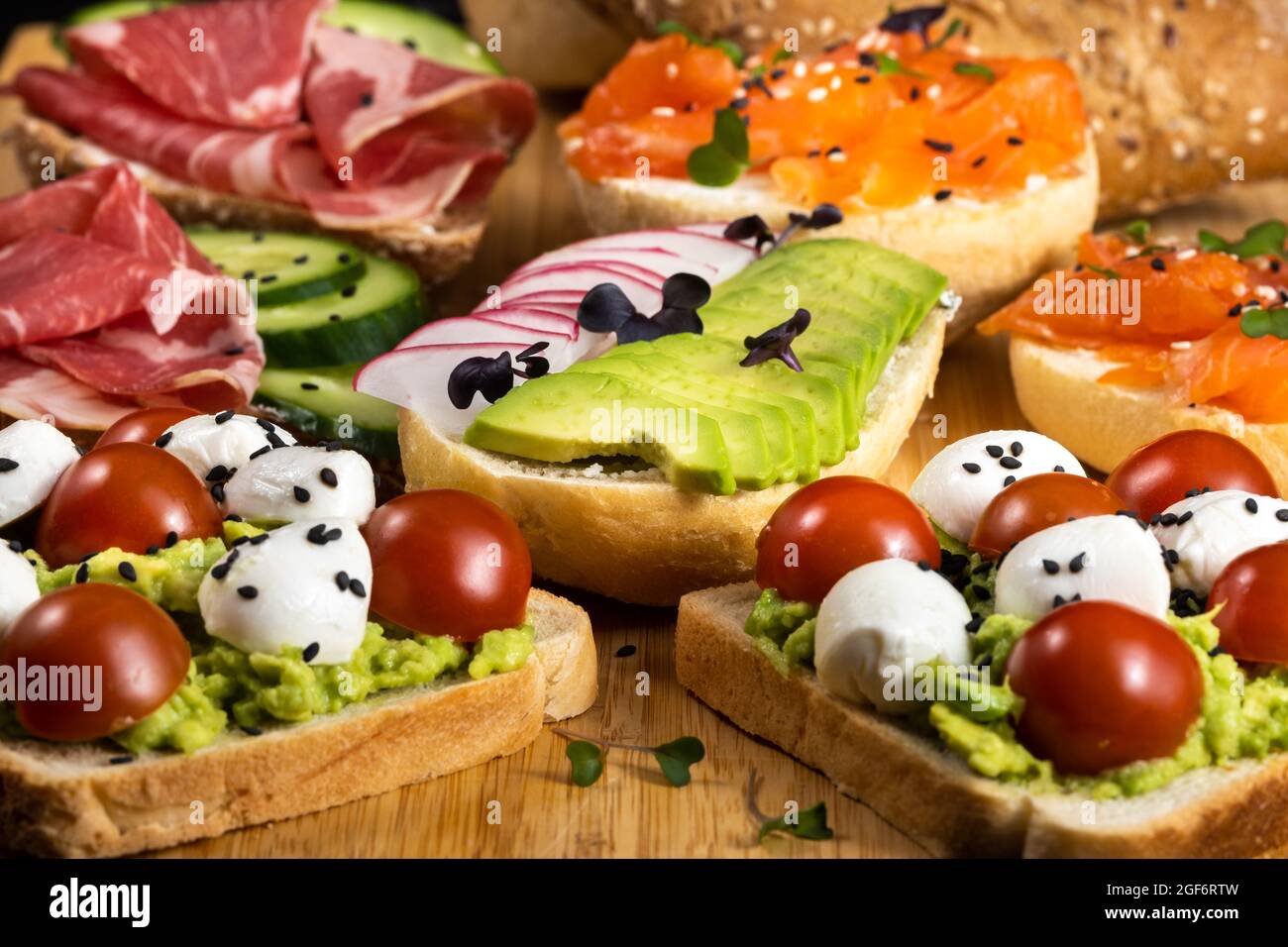 Assorted sandwiches with fish, cheese, meat and vegetables lying on the ...