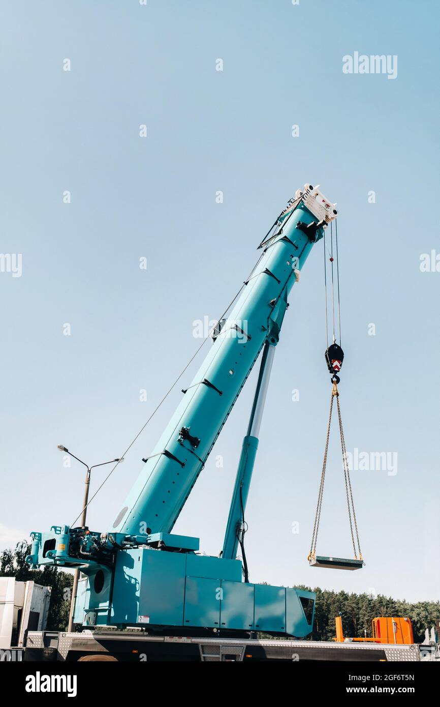 the stove is loaded onto a large blue car crane and prepared for ...