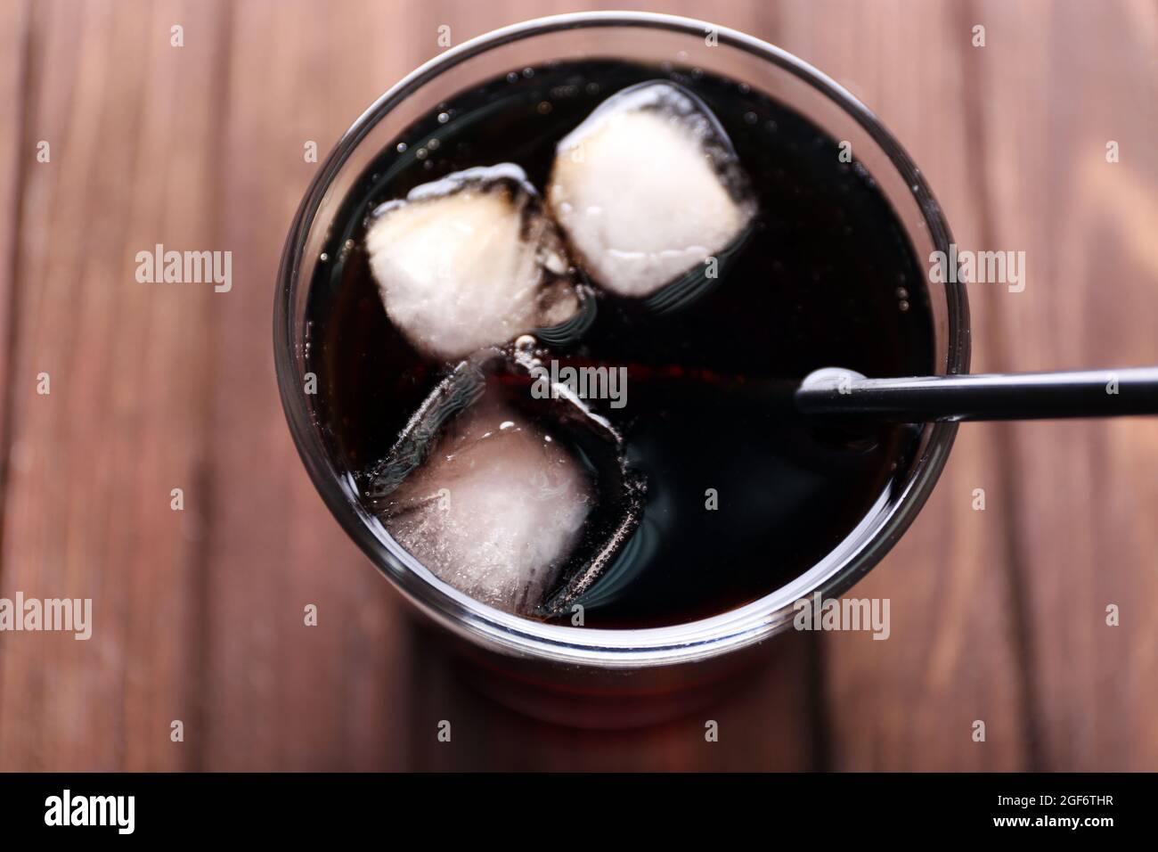 Cocktail with ice blocks and tubule on wooden background, top view ...