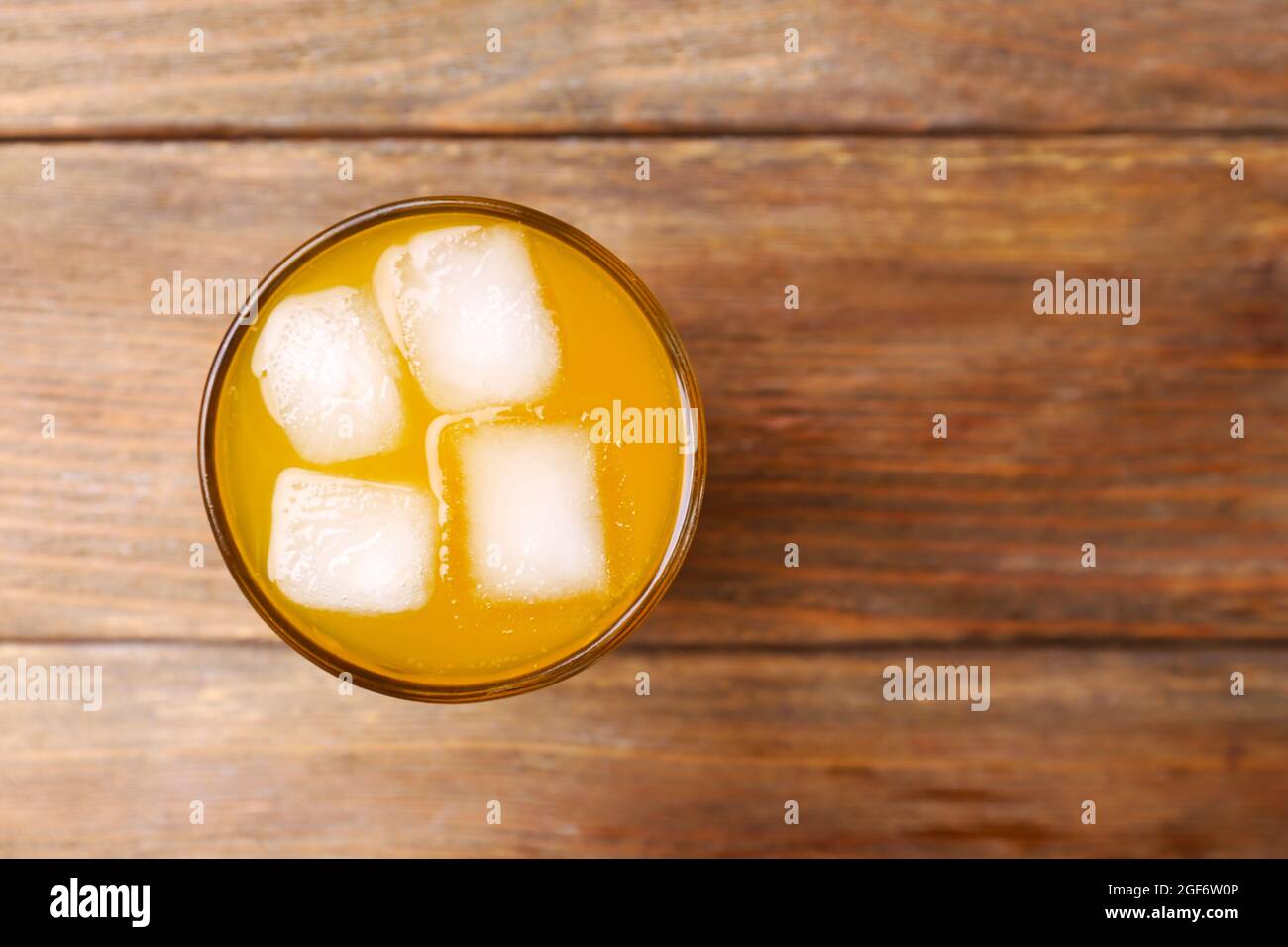 Glass of orange juice with ice block on wooden background Stock Photo ...