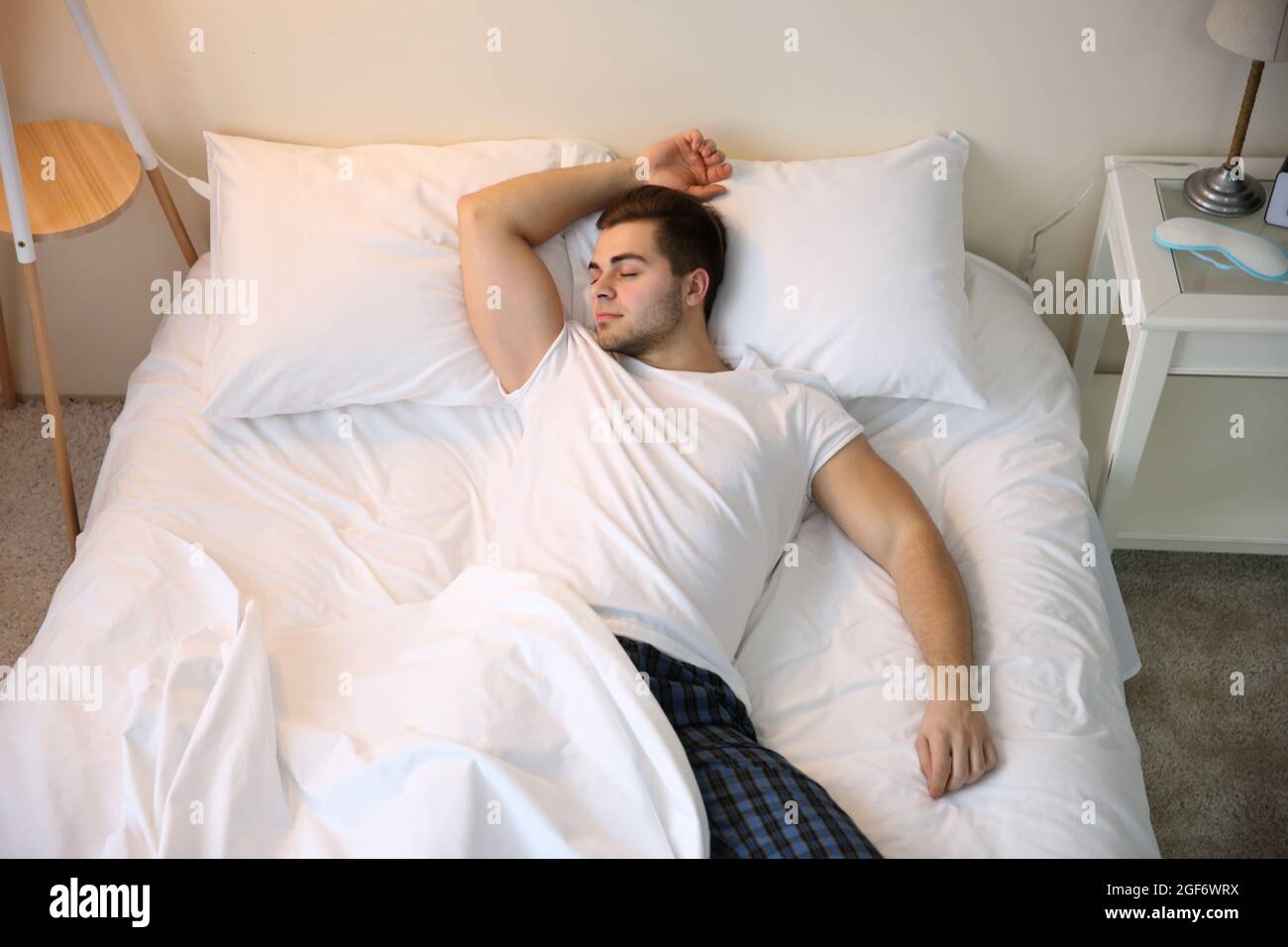 Young man sleeping in bed at home Stock Photo - Alamy